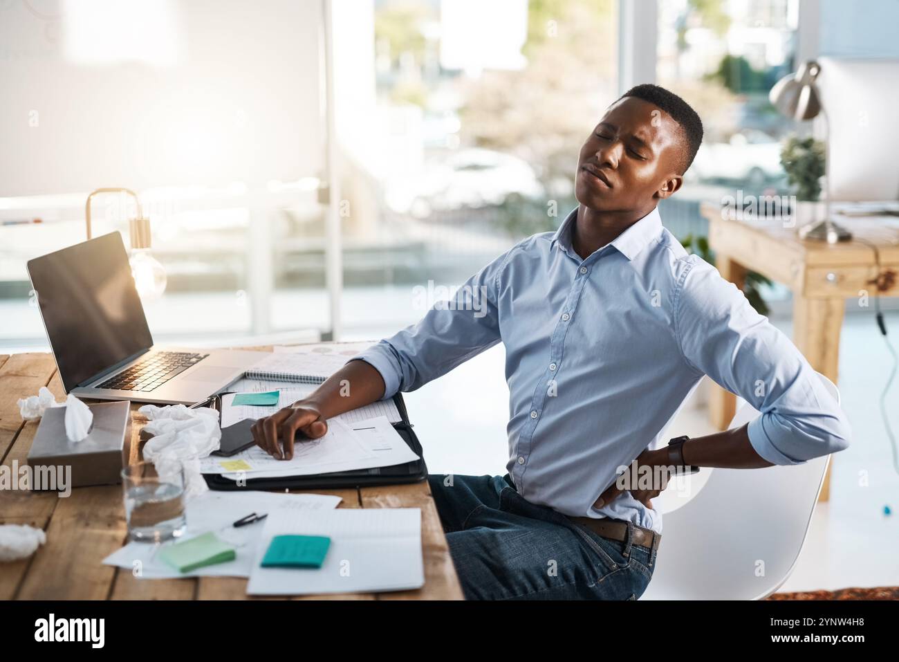 Office, stress and black man at laptop with back pain, fatigue and ...