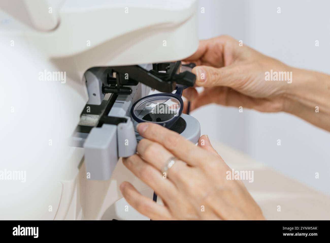 Optician preparing eyeglasses using lensmeter for graduation Stock ...
