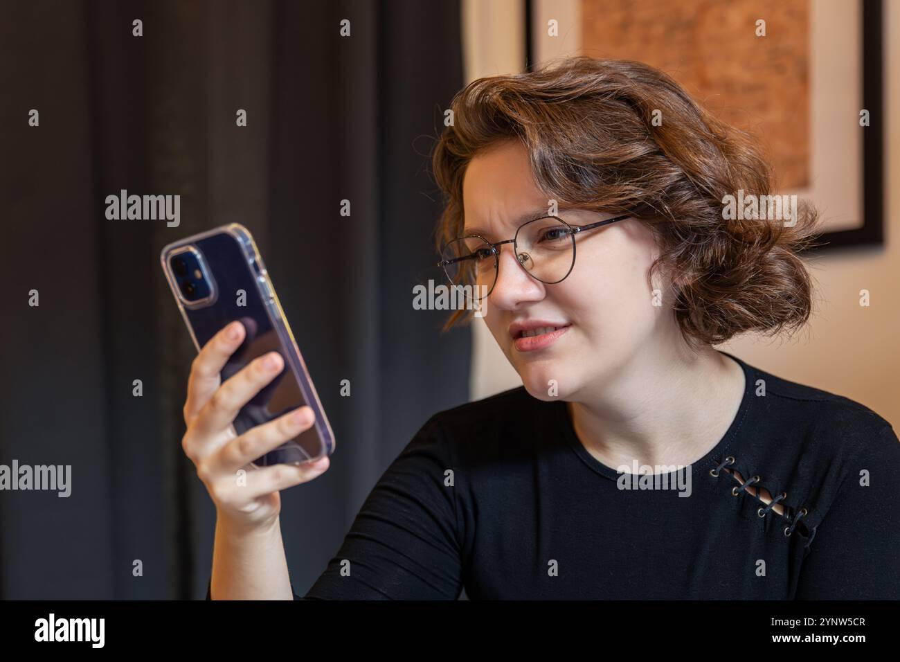 Busy and serious young woman with phone. Emotion and technology concept ...