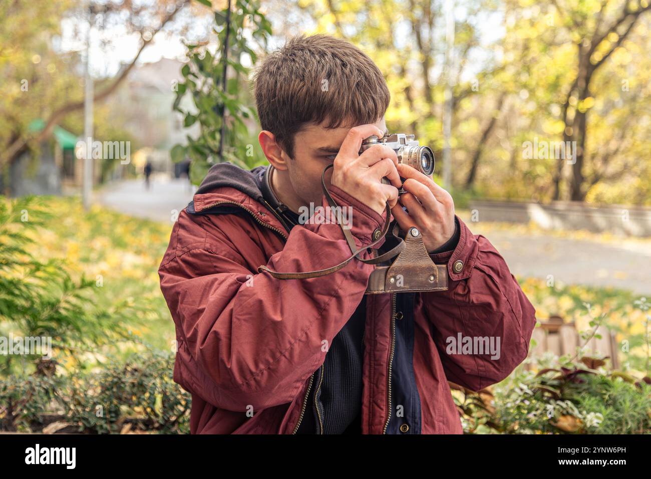 A young man takes pictures on a vintage camera. Film camera photography ...