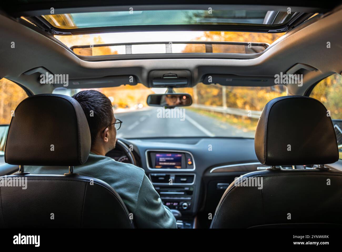 Driving the modern car on asphalt road. A young man drives a car Stock ...
