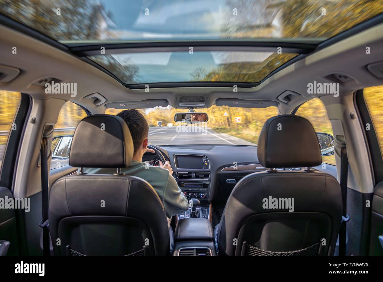 Driving the modern car on asphalt road. A young man drives a car Stock ...