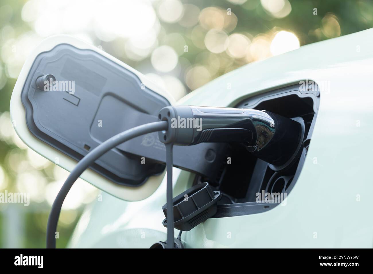 An electric vehicle charger is plugged into the charging port ...