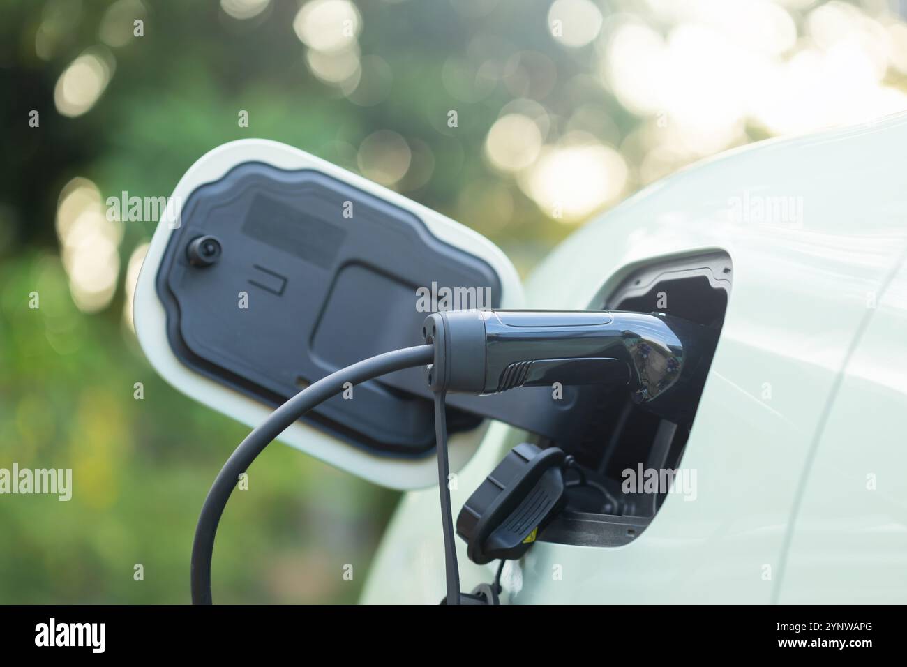 An electric vehicle charger is plugged into the charging port ...