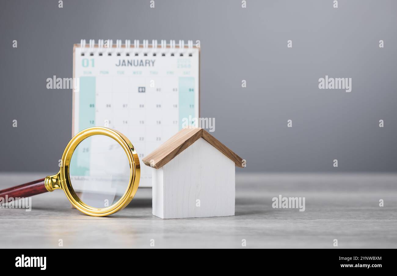 A 2025 calendar, house model, and magnifying glass on a table. The ...