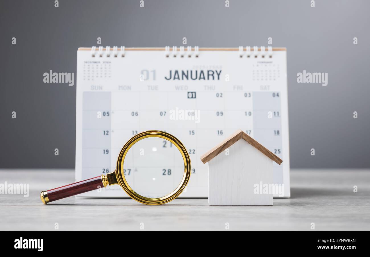 A 2025 calendar, house model, and magnifying glass on a table. The ...