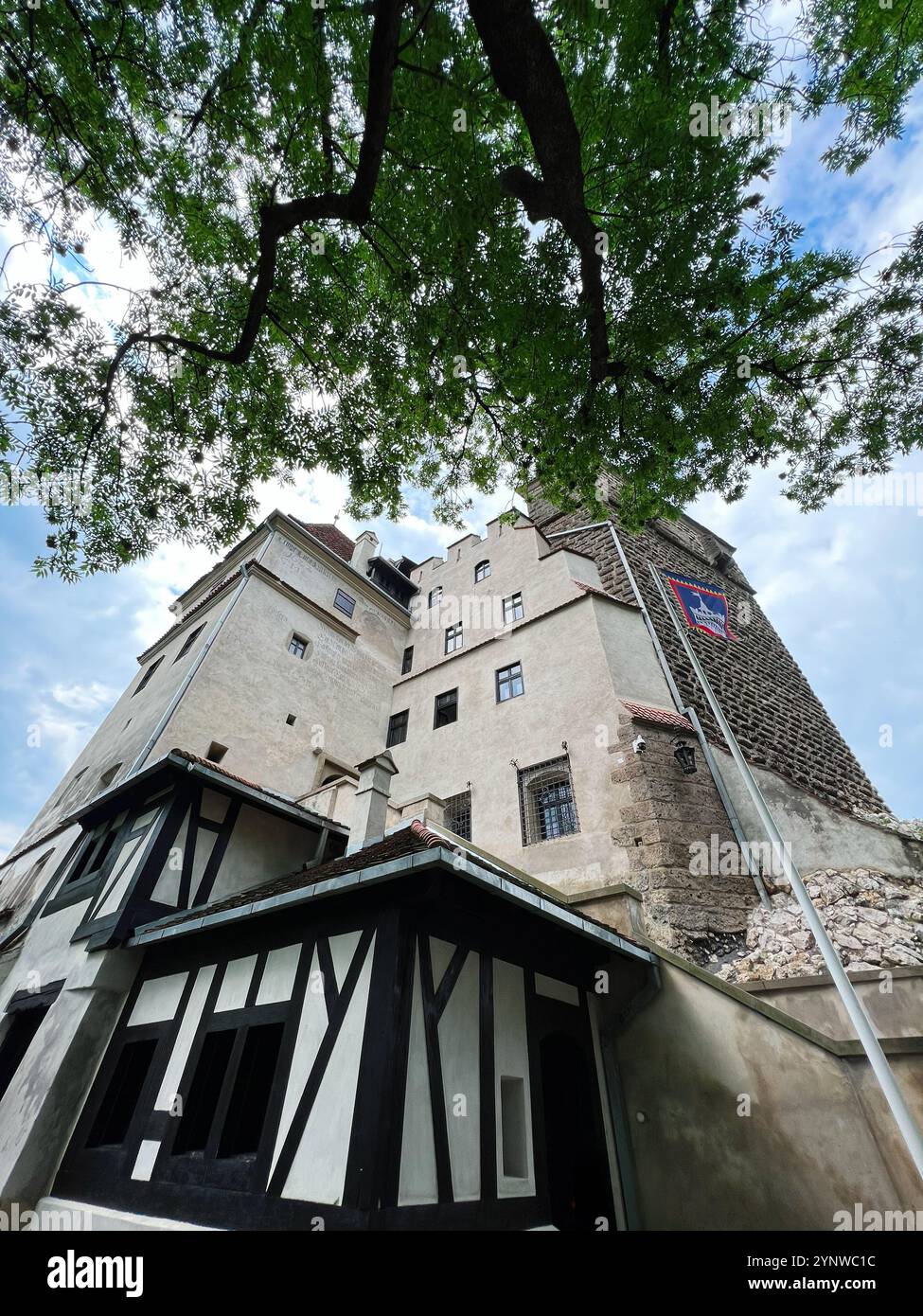 Tall historic Bran castle with a medieval architecture stands beneath a ...