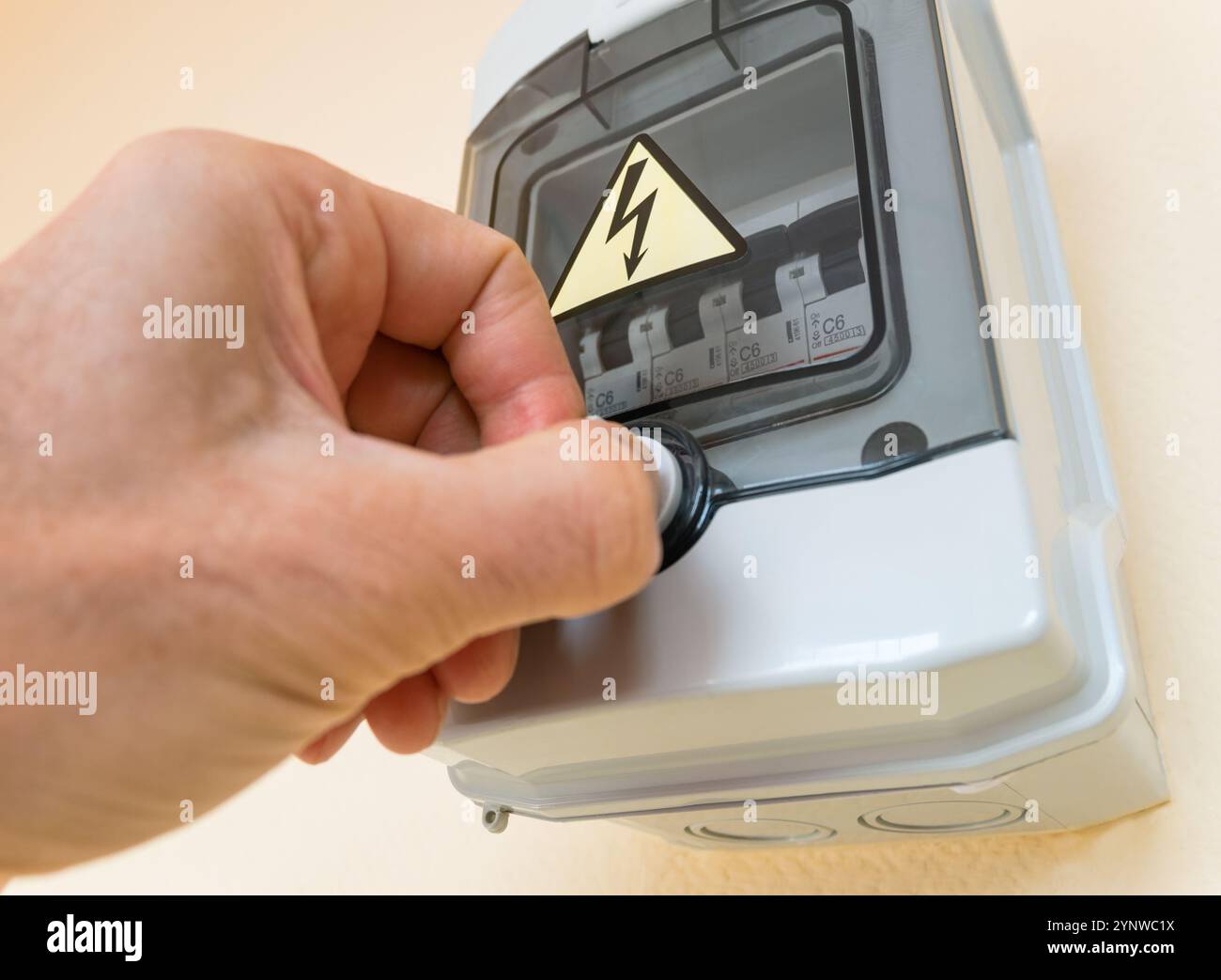 A man's hand opens the lid of a box with electrical automatic safety ...