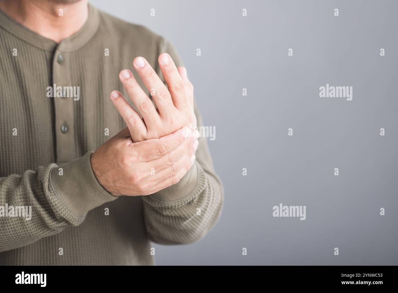 A man presses his palm, showing signs of numbness and pain in his hand ...