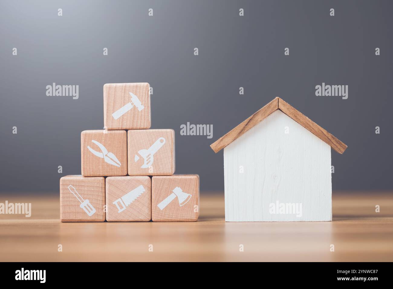 A house model and wooden blocks with tool symbols represent home repair ...