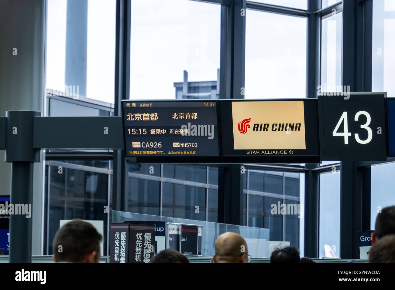 Flight information display at airport showing boarding for Beijing ...