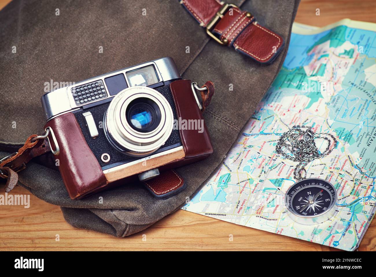 Travel, map and compass with camera on table for itinerary schedule ...