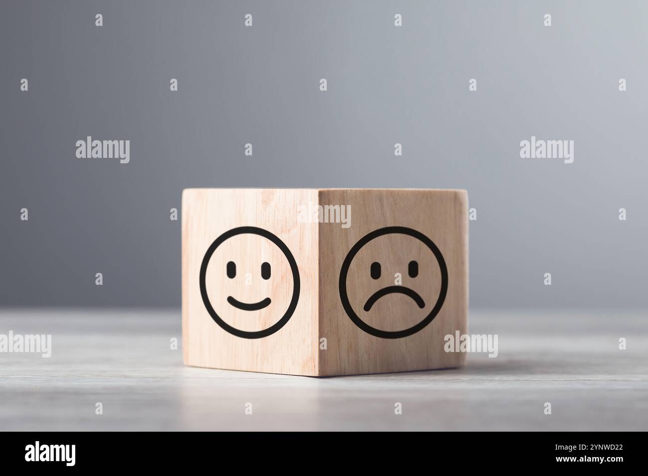 Wooden blocks displaying a sad face transitioning to a happy face ...