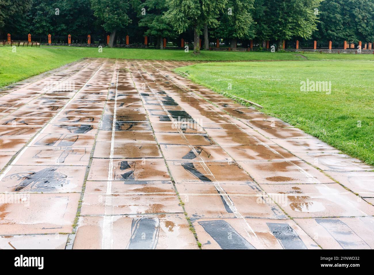 Old damaged running track in stadium with faded white lines and broken ...