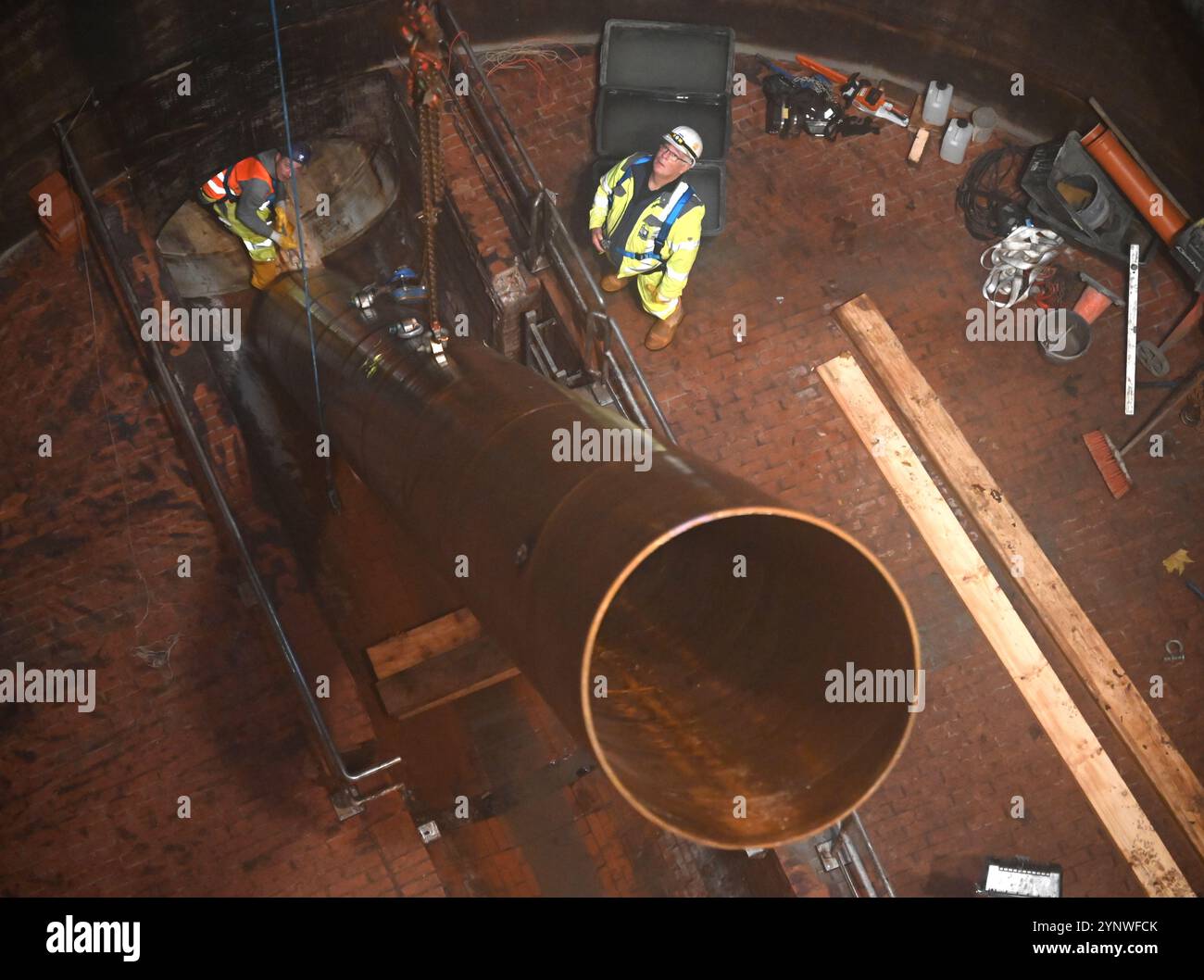 27 November 2024, Hamburg: The pipe section is held in the shaft by a ...