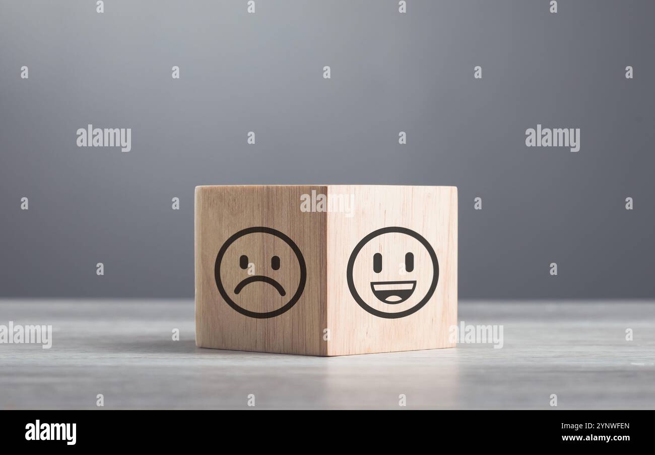 Wooden blocks displaying a sad face transitioning to a happy face ...