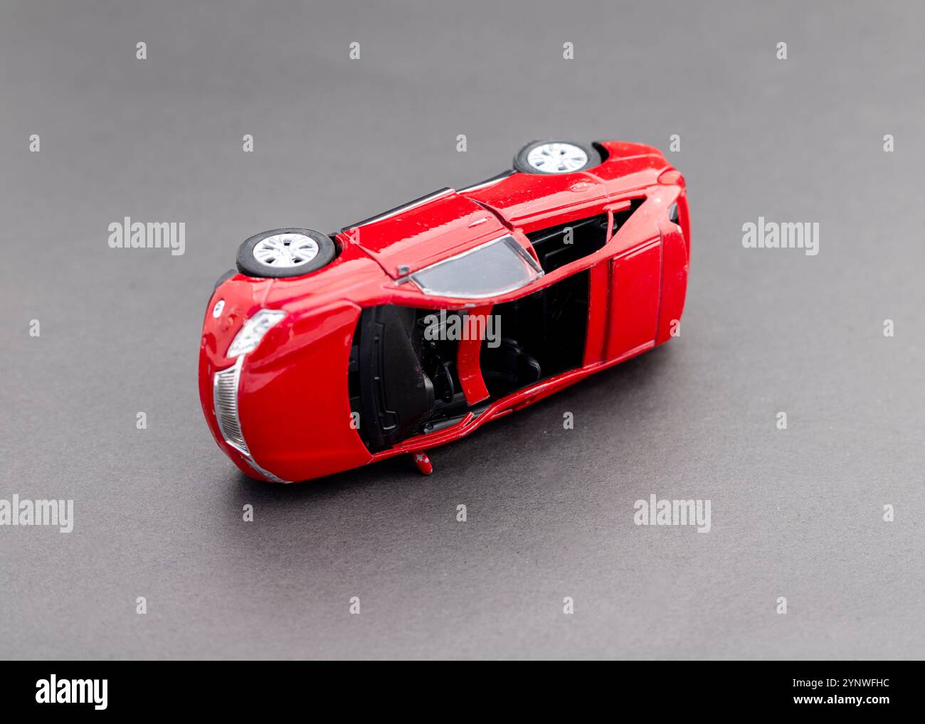 Red toy car model on Its side after accident on road Stock Photo - Alamy