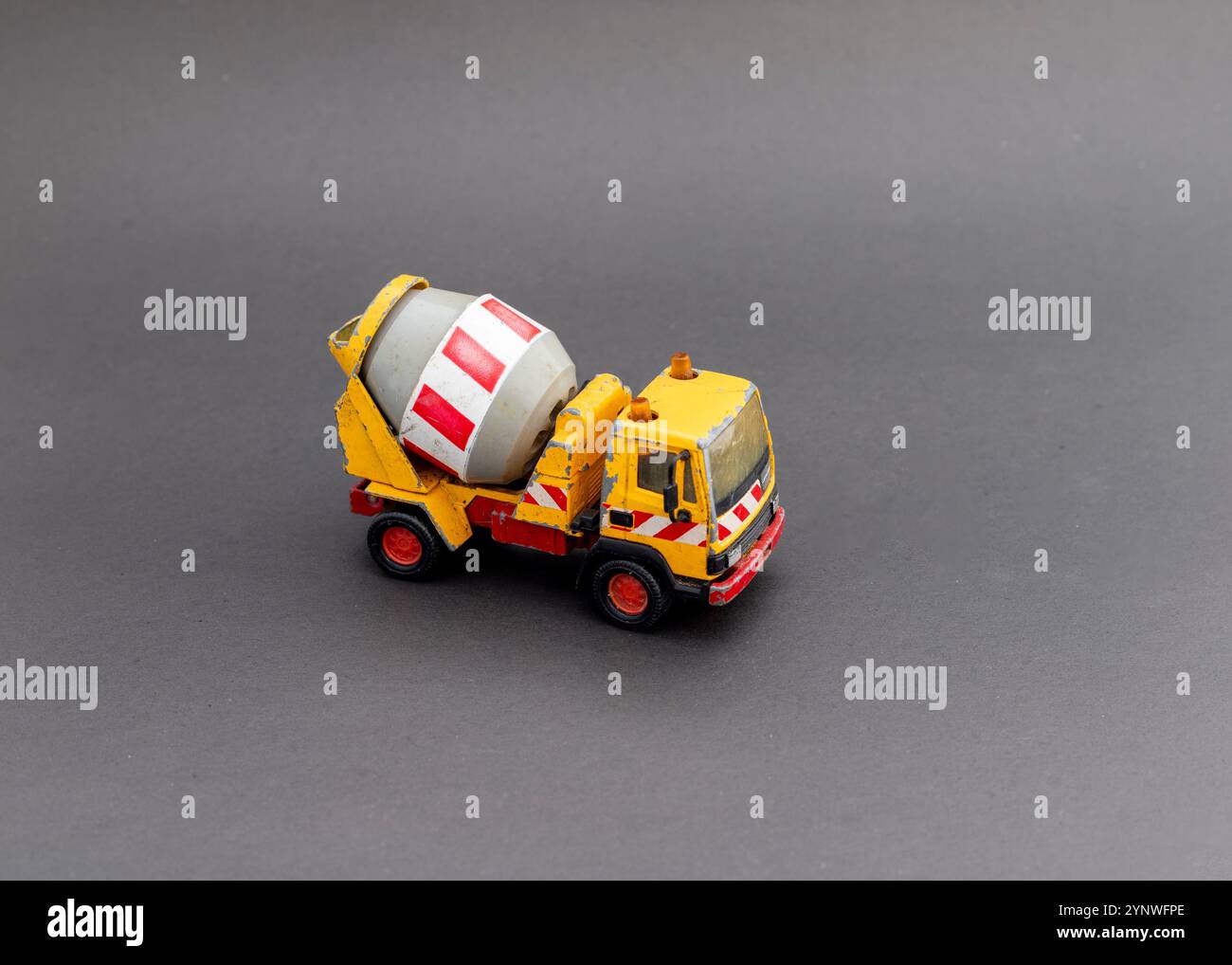 Yellow cement mixer toy truck on grey background Stock Photo - Alamy