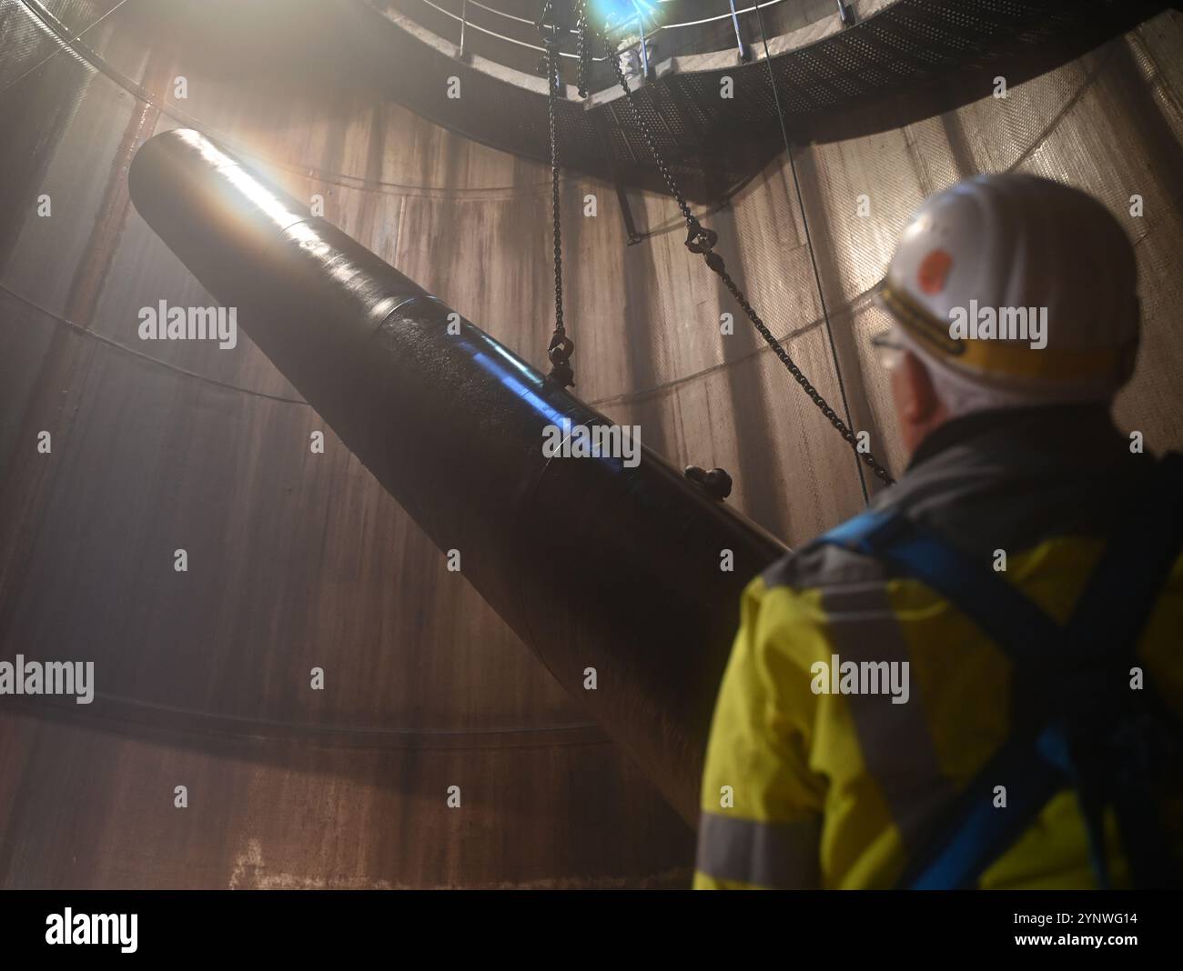 27 November 2024, Hamburg: A construction worker looks at the pipe ...