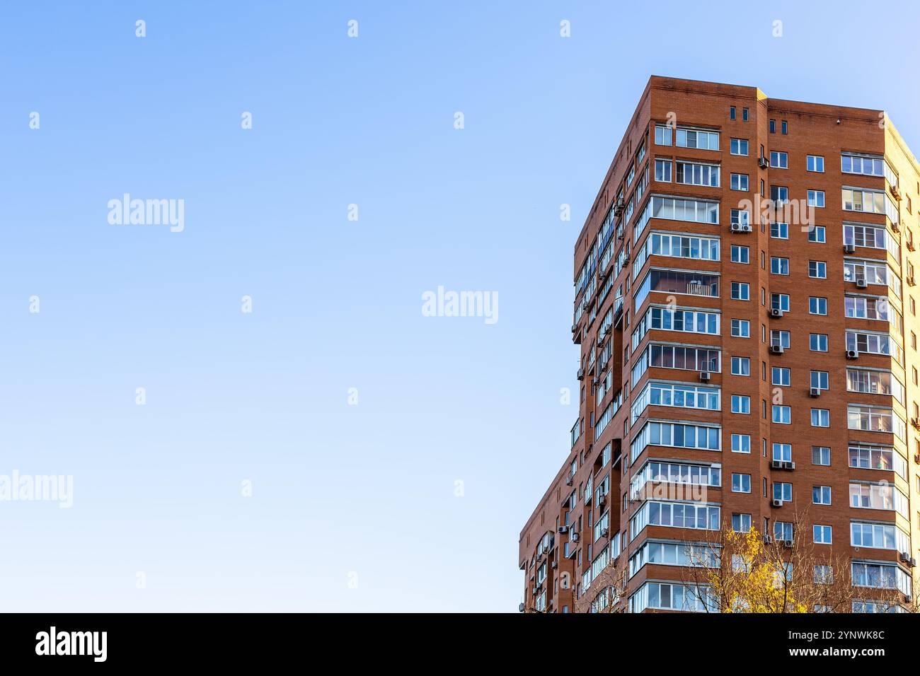 brick high-rise apartment building and blue sky in autumn eveving ...