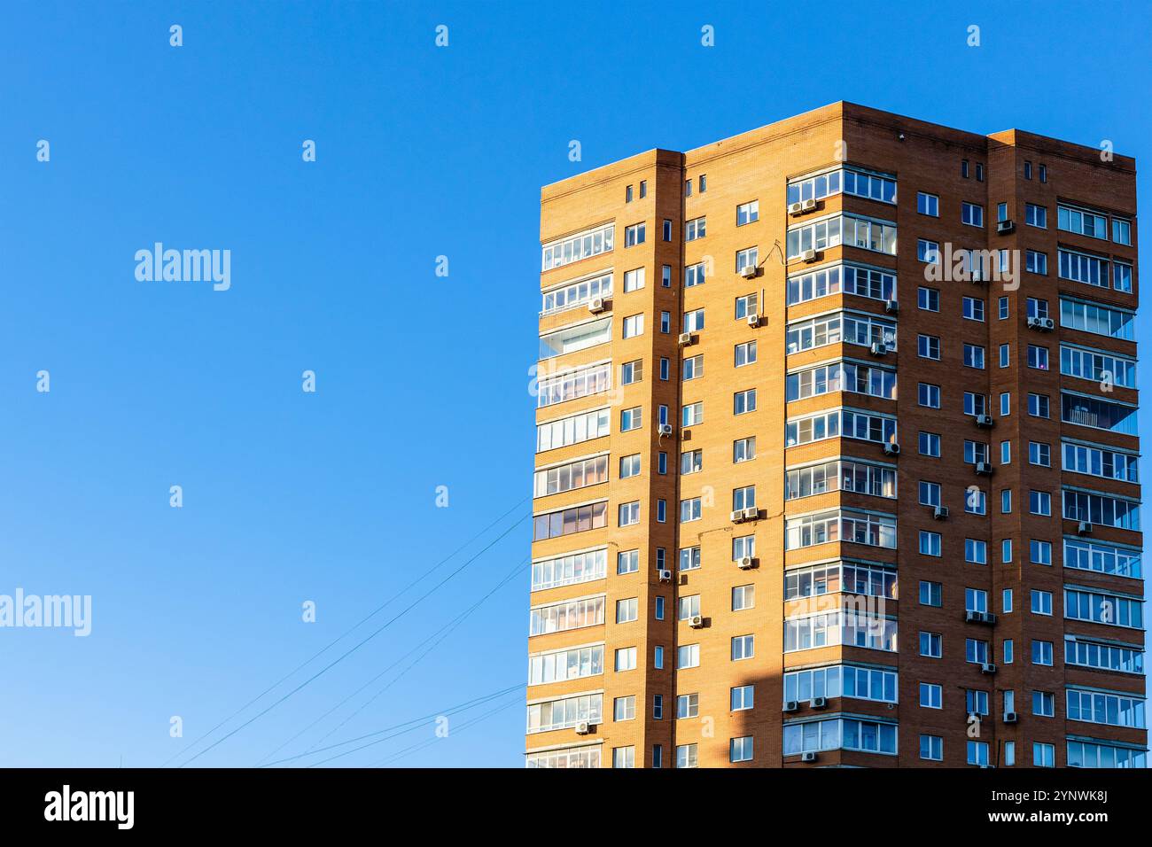 tower of brick high-rise apartment building illuminated by sunset sun ...