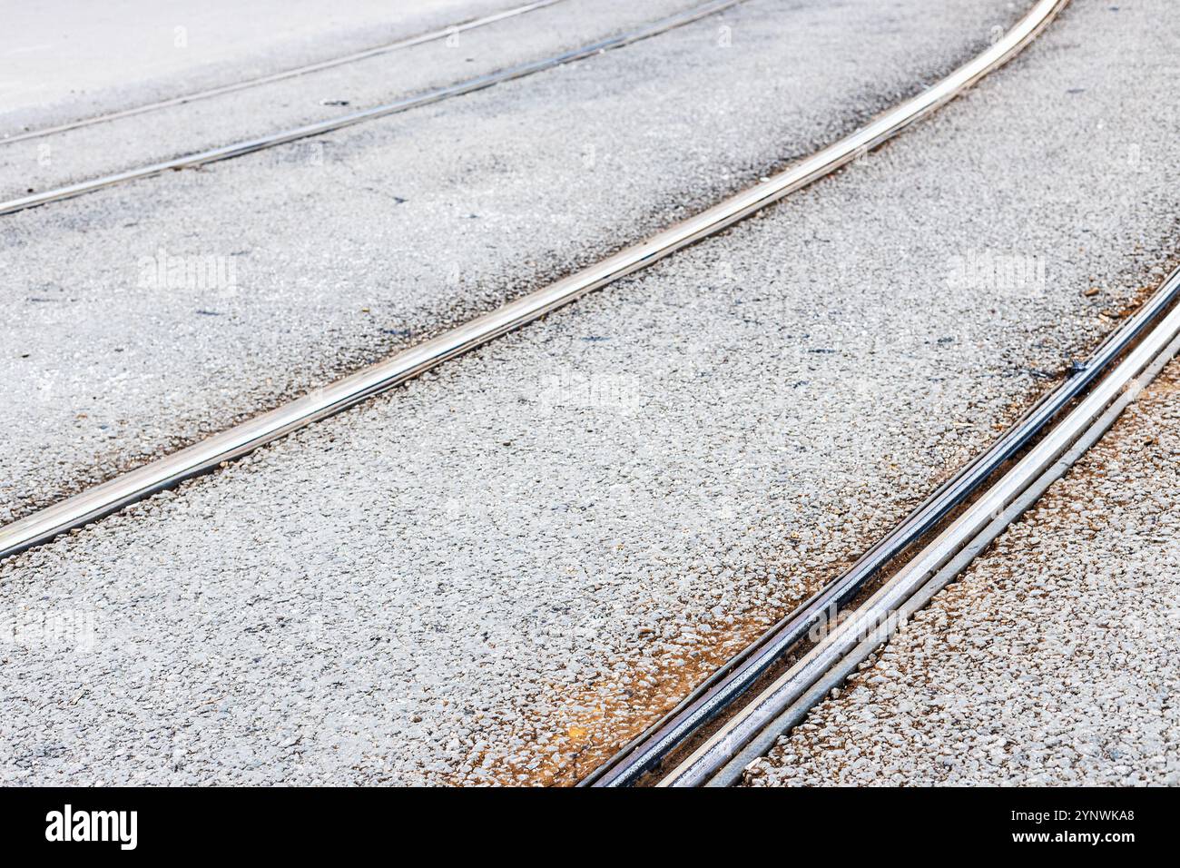 steel rails of tram railway on surface of city road in evening twilight ...