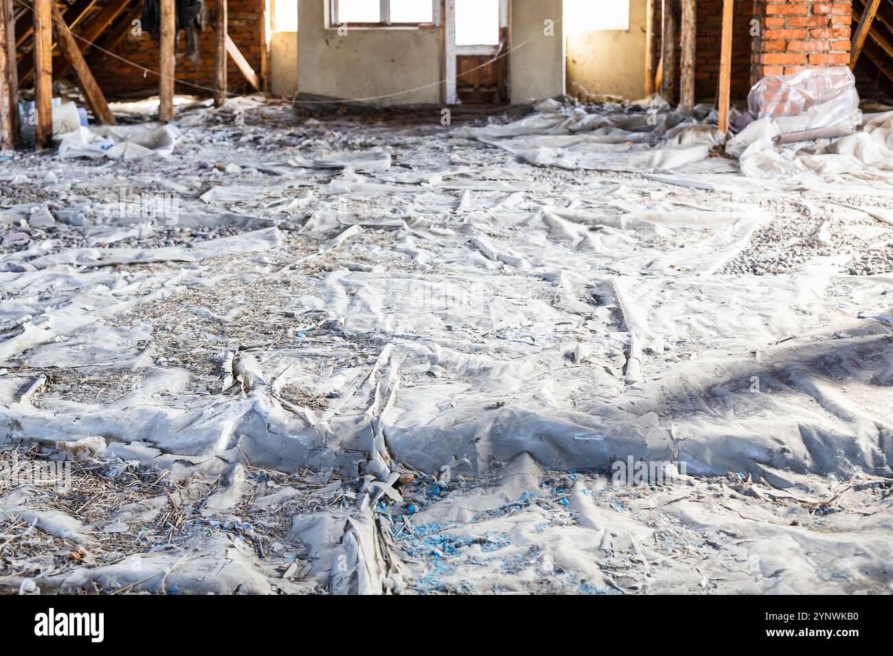 attic floors covered with polyethylene film and debris with expanded ...