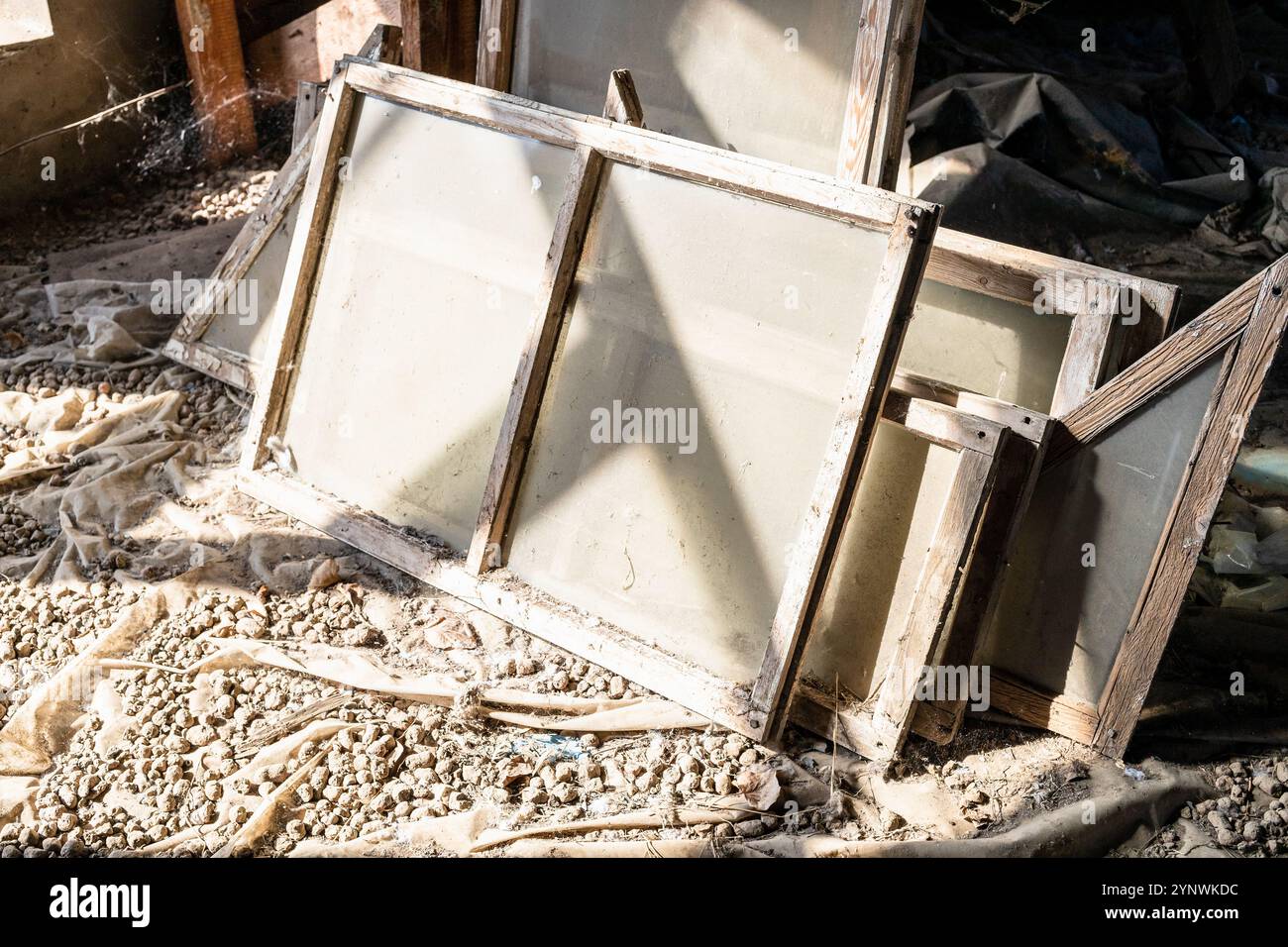 demounted old glass and wooden window frames in attic of village house ...