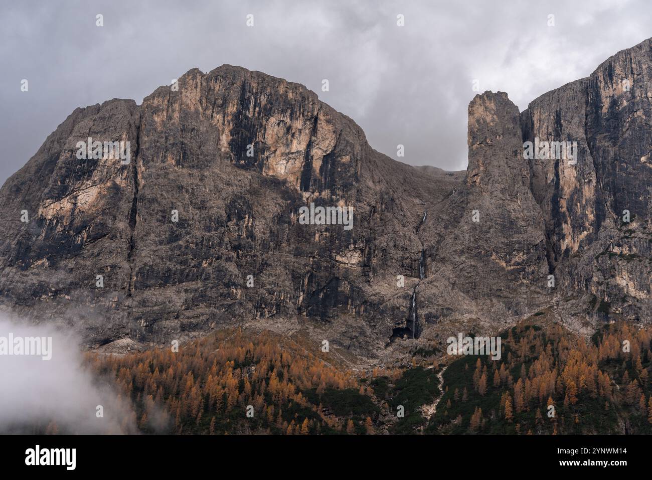 A landscape with dark clouds above tall limestone cliffs above Corvara ...