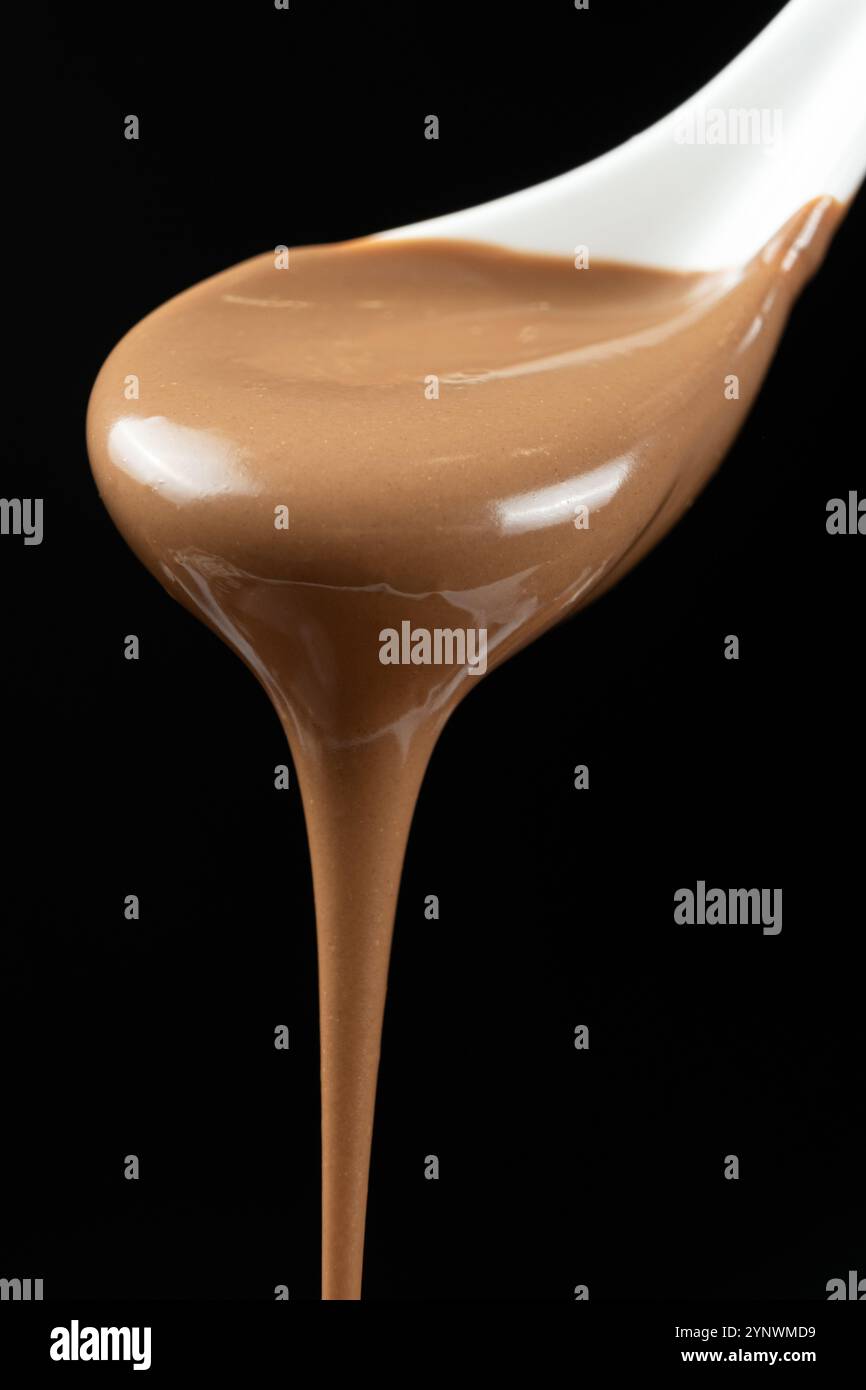 Melted milk chocolate poured out of a spoon Stock Photo - Alamy