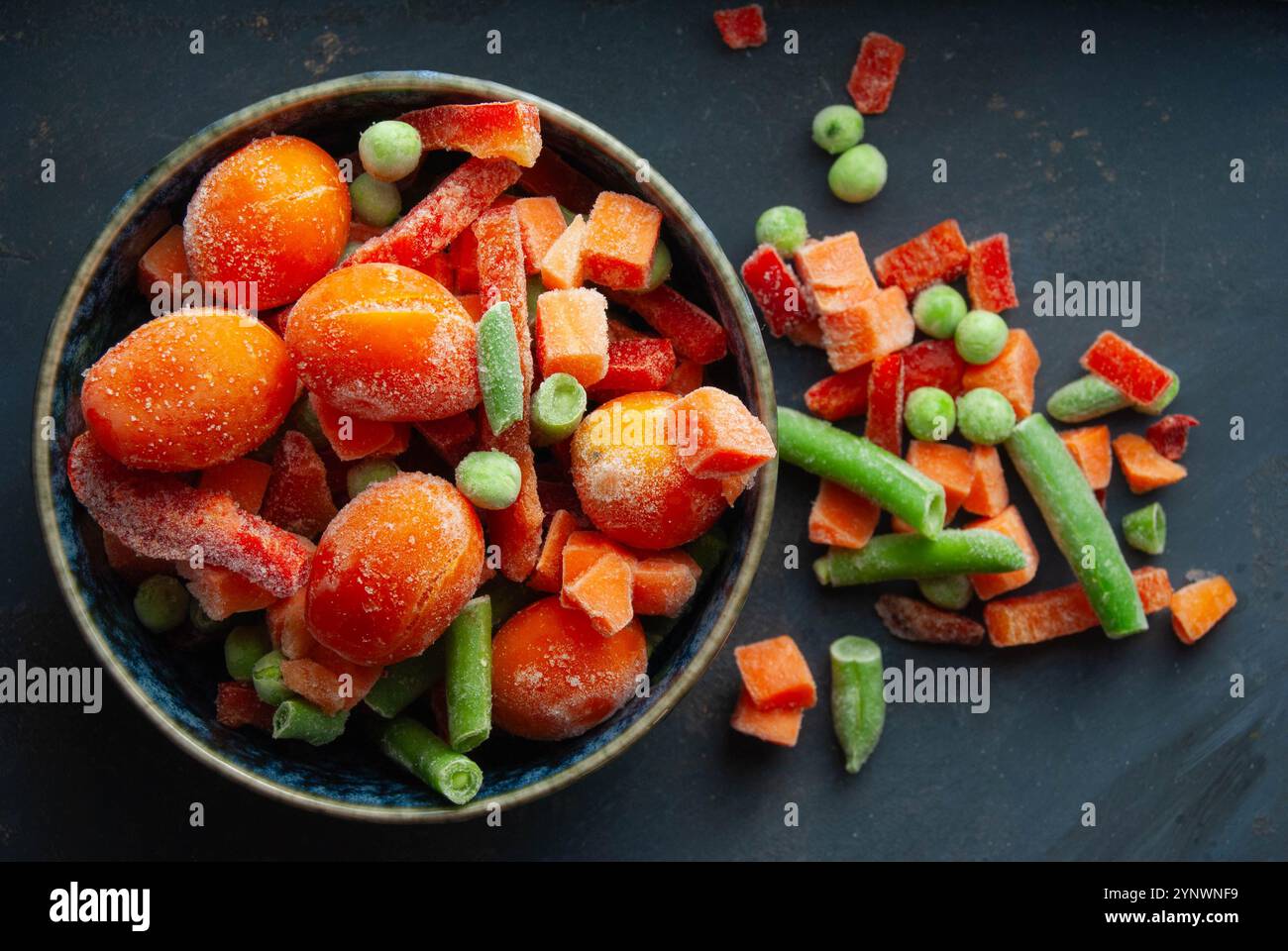 A vibrant mix of frozen vegetables in a bowl, showcasing their bright ...