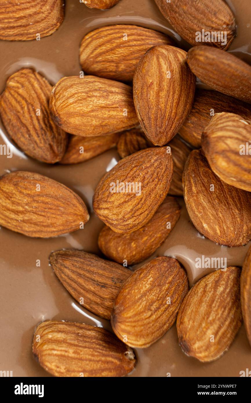 Almond nuts in melted milk chocolate macro Stock Photo - Alamy