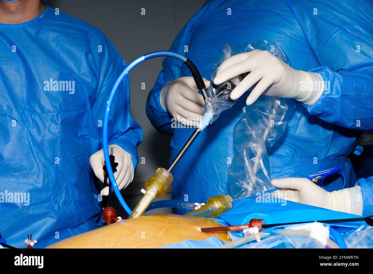 The hands of a surgeon in sterile white gloves operate with ...