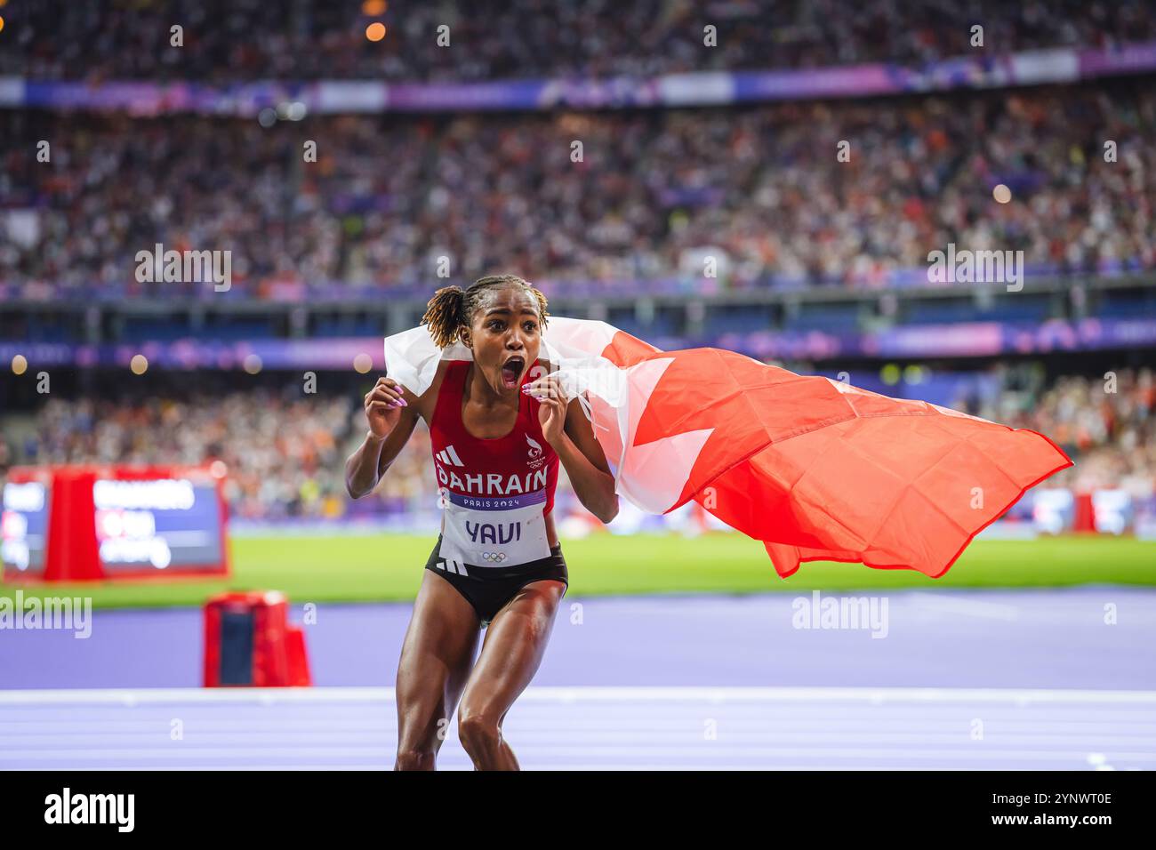 Winfred Yavi celebrating her medal with her country's flag at the Paris ...