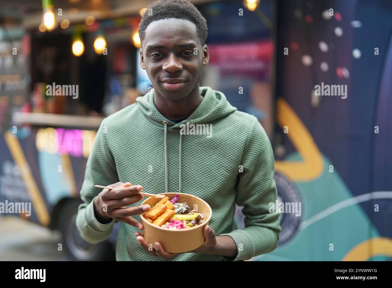 Portrait Of Teenage Boy Eating Vegan Mezze Bowl At Outdoor Street Food ...