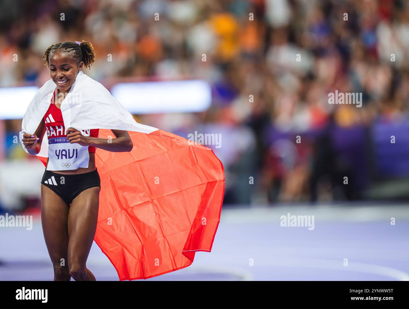 Winfred Yavi celebrating her medal with her country's flag at the Paris ...