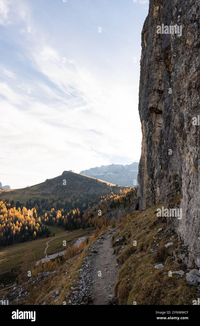 Vertical photo of a dolomite hiking trail, blue skies, and a tall rock ...