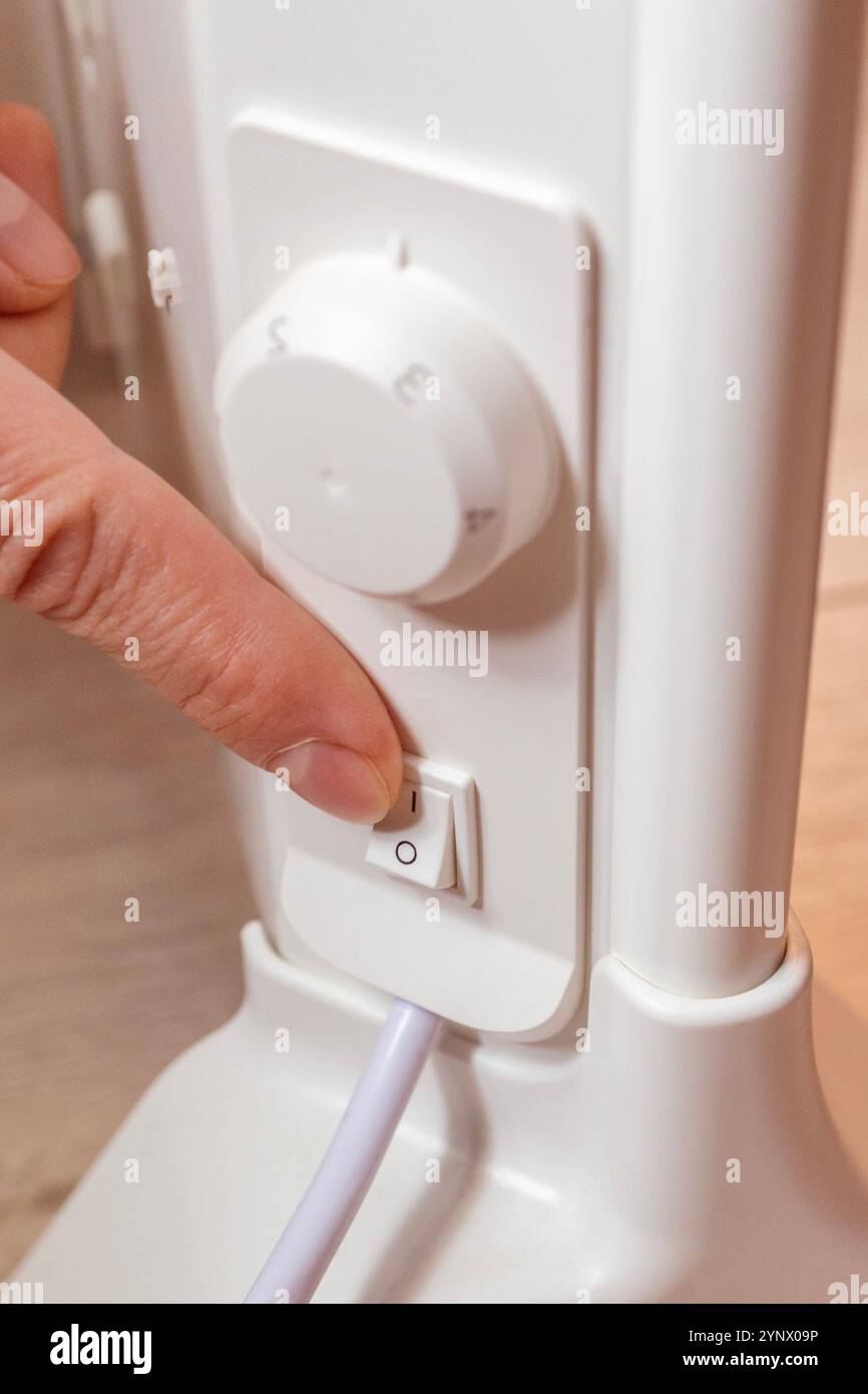 Energy saving. Switch off button of the electrical appliance. Finger on ...