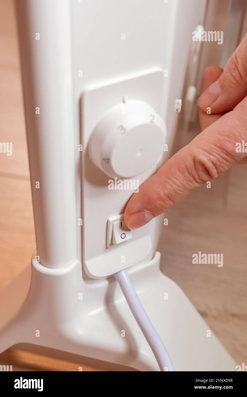 Energy saving. Switch off button of the electrical appliance. Finger on ...