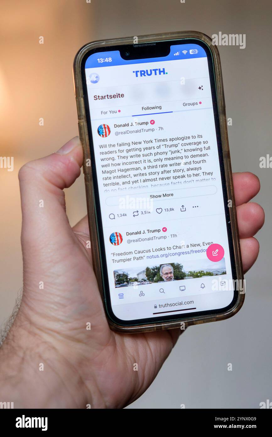 Mobile phone in one hand on Truth social. Truth Social is a US social ...