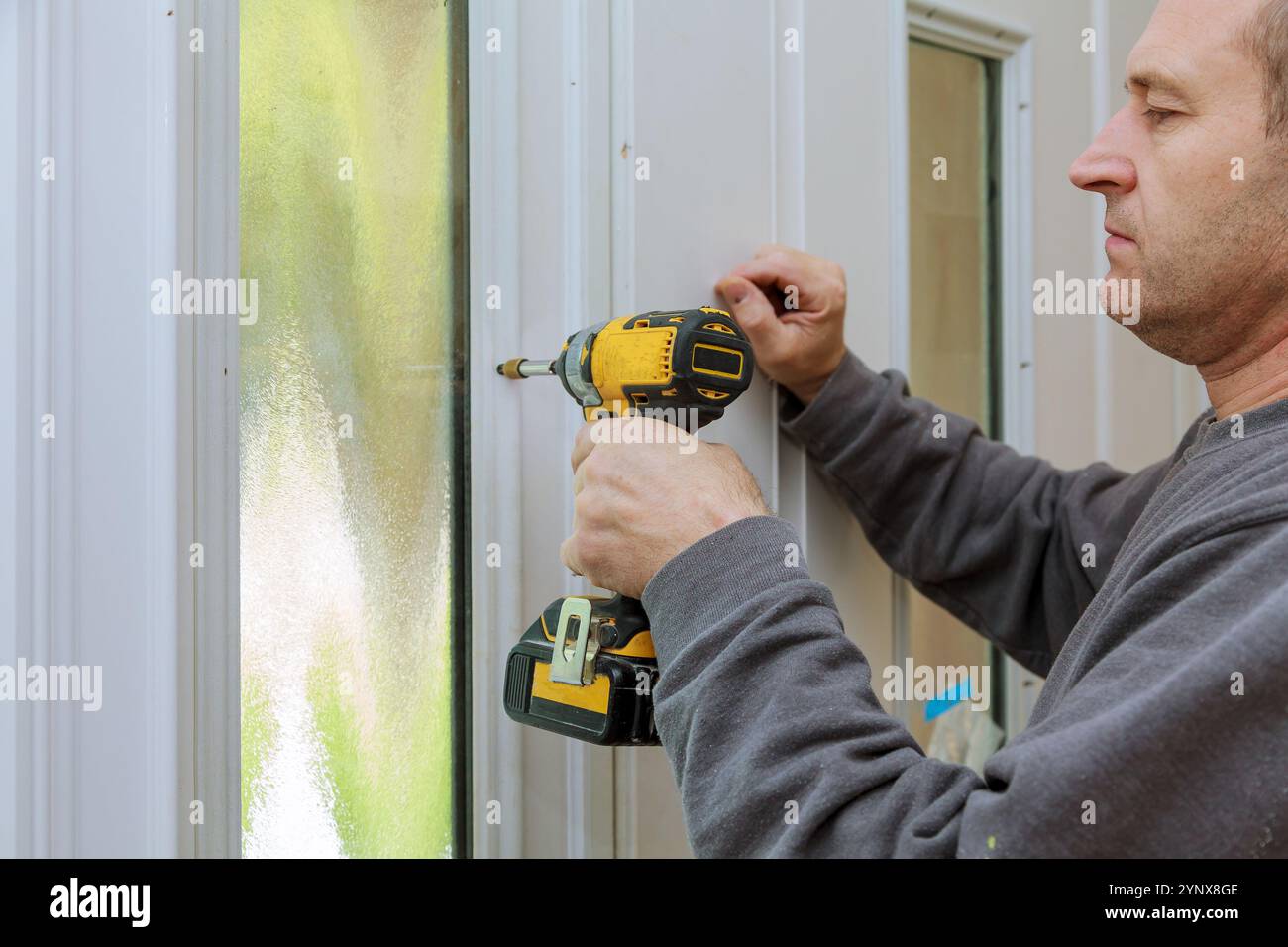 Man focuses on using drill hi-res stock photography and images - Alamy