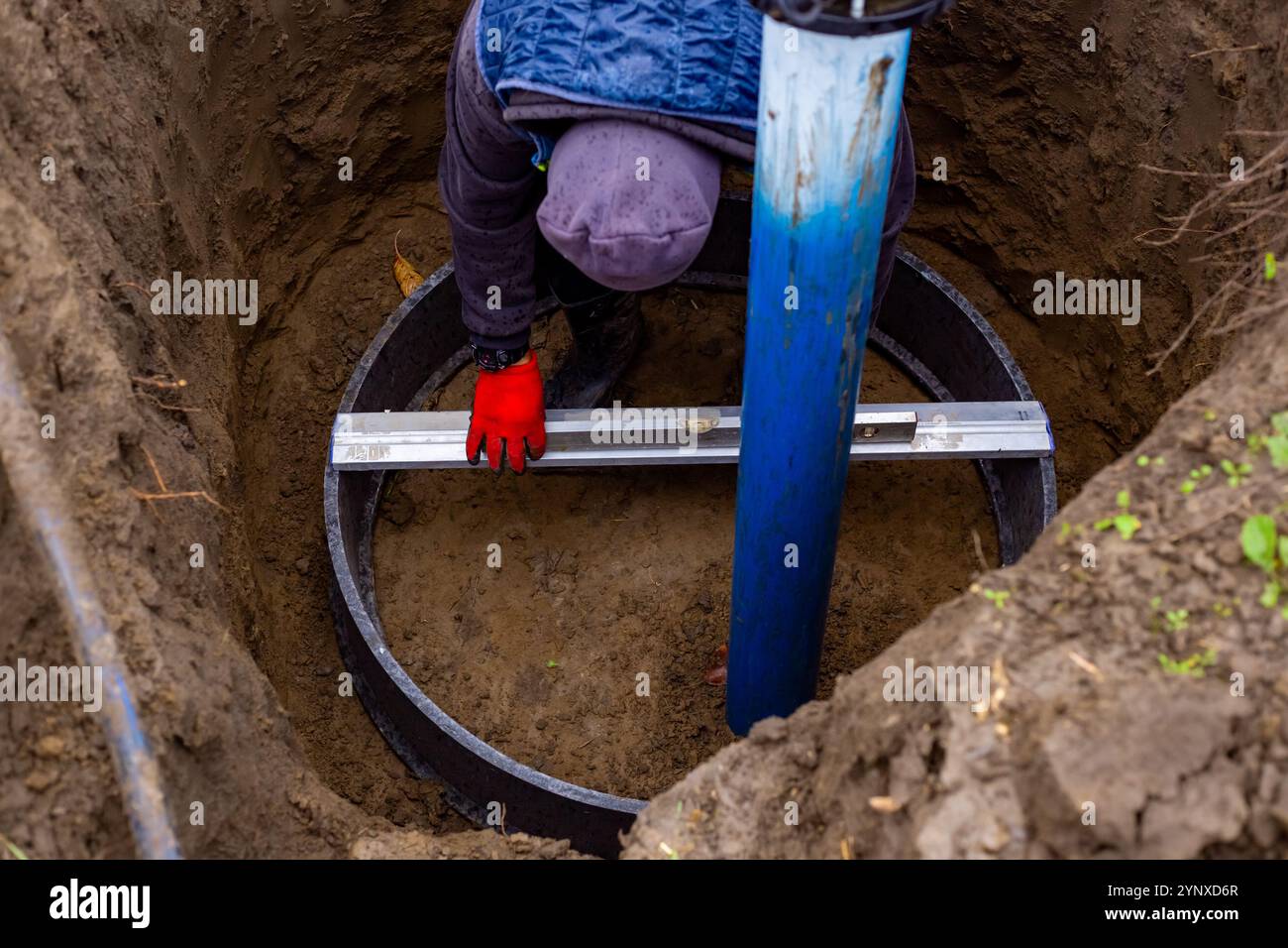 Workers install a water intake unit in a well. Installation of the ...