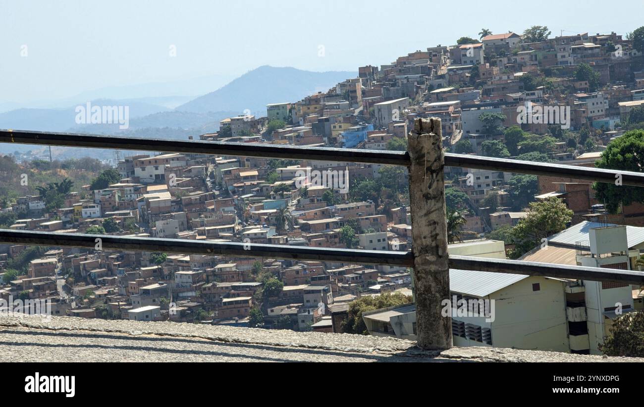 A fence is on a hill overlooking a city with many buildings. The fence ...