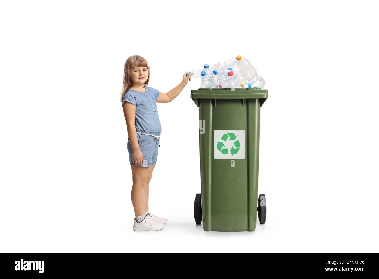 Child throwing an empty plastic bottle in a recycle bin isolated on ...