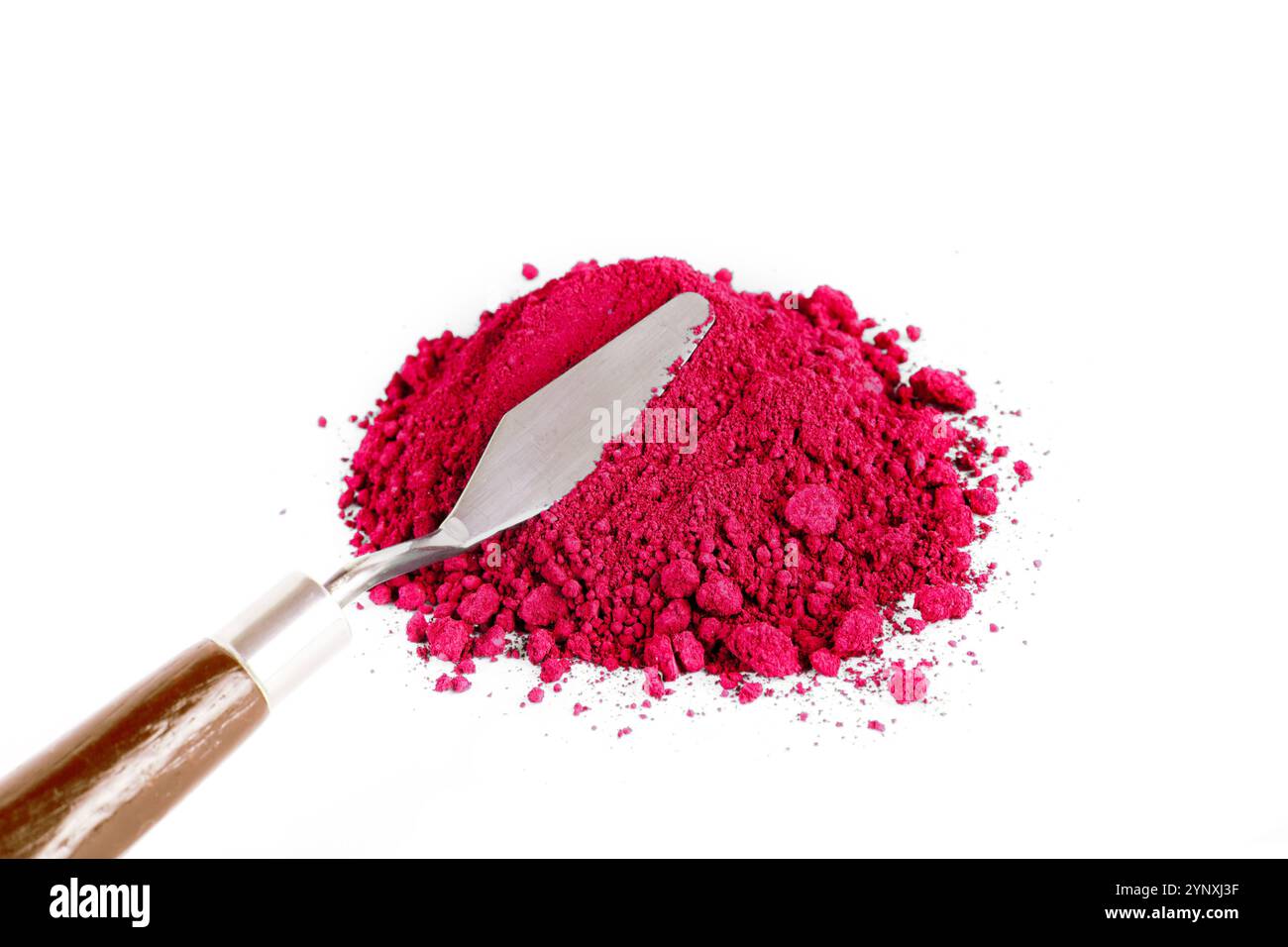 A container tipped over, spilling bright red powder across a white ...