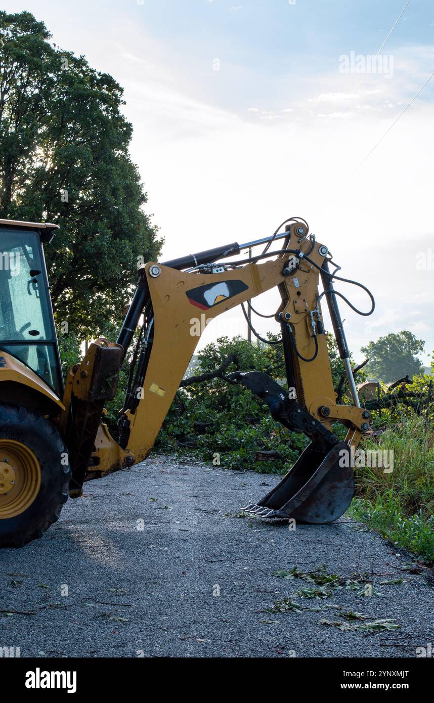 Thea wind storm has passed, now a big yellow backhoe waits in the road ...