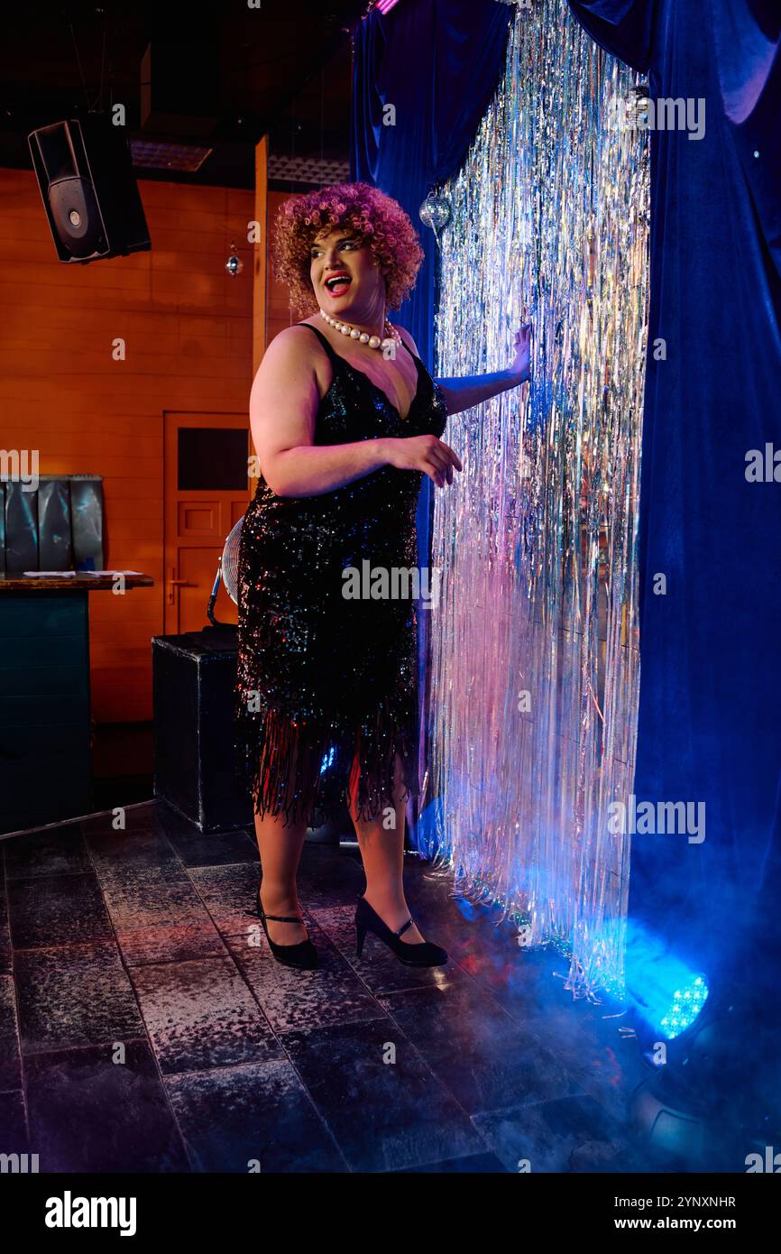 An androgynous drag queen with striking makeup entertains at a festive ...