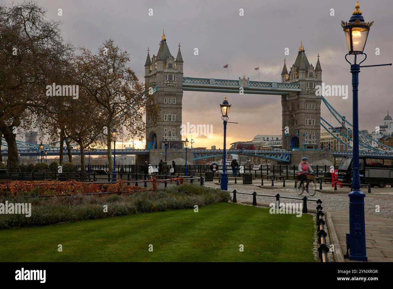 Cobbled pathway, lawn and streetlight in front of Tower Bridge, London ...