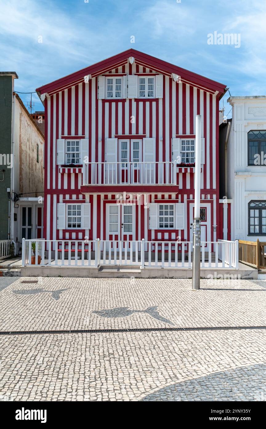 A traditional striped house stands proudly in a quiet coastal town ...