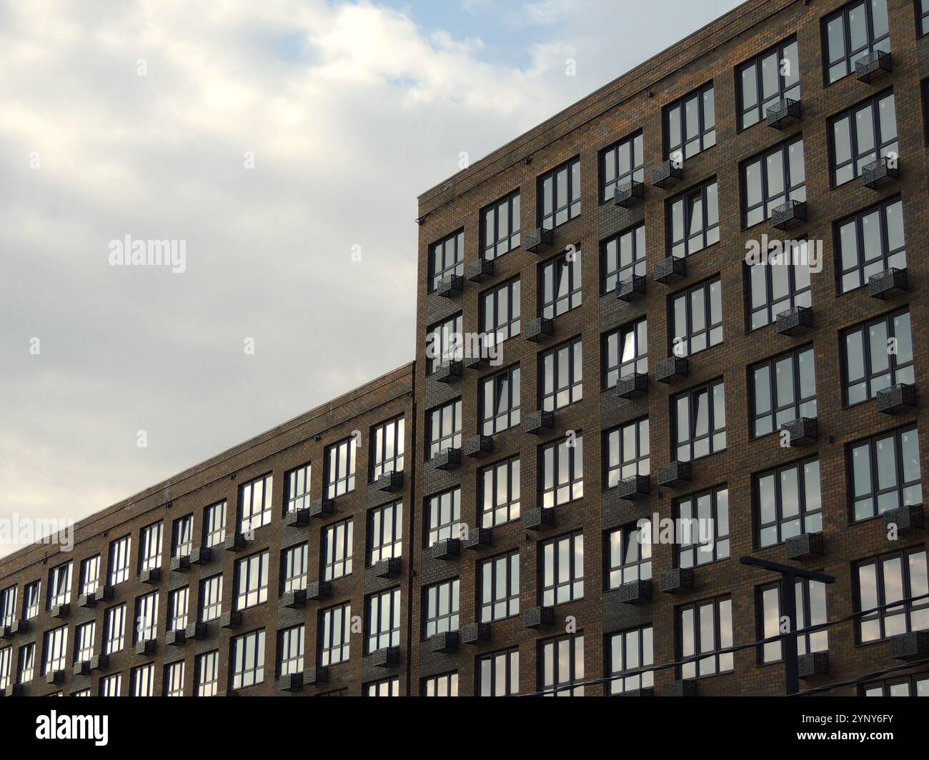 brown brick house with windows and air conditioner boxes on the sky ...